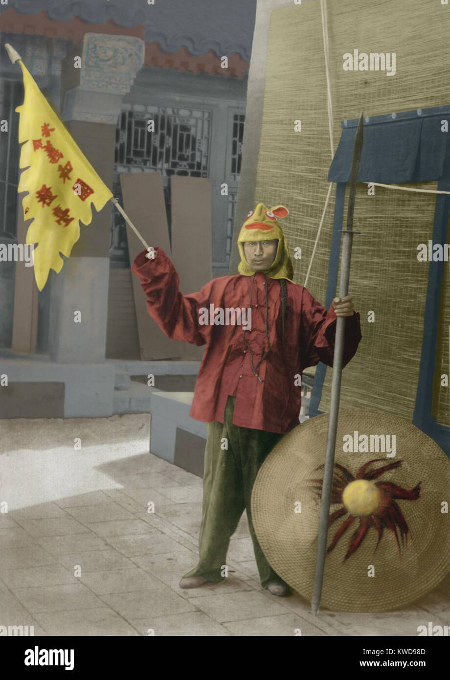 Chinese 'Boxer' with shield and banner on urban street, c. 1900. The ...