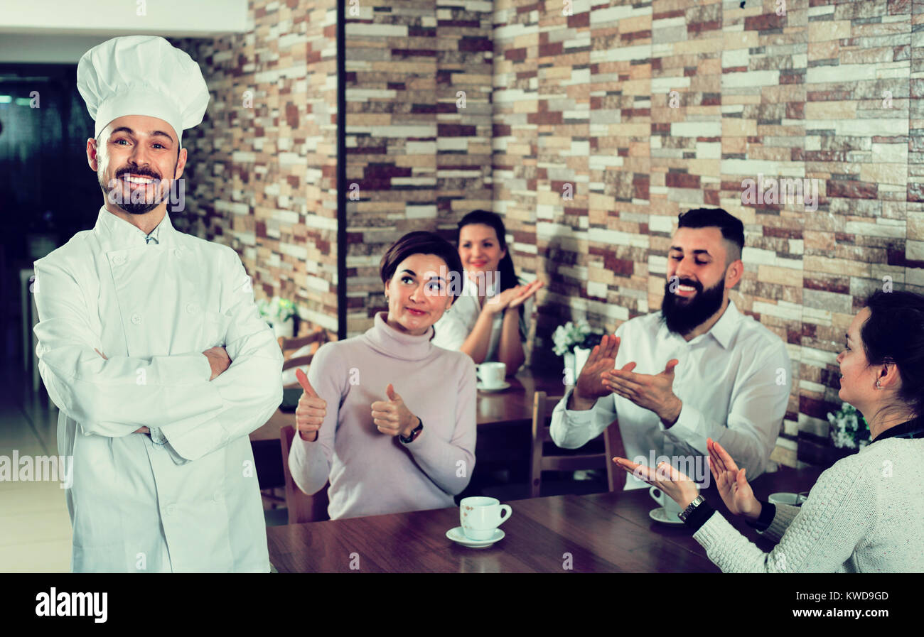 Cheerful positive smiling chef listens to praise of the food Stock ...