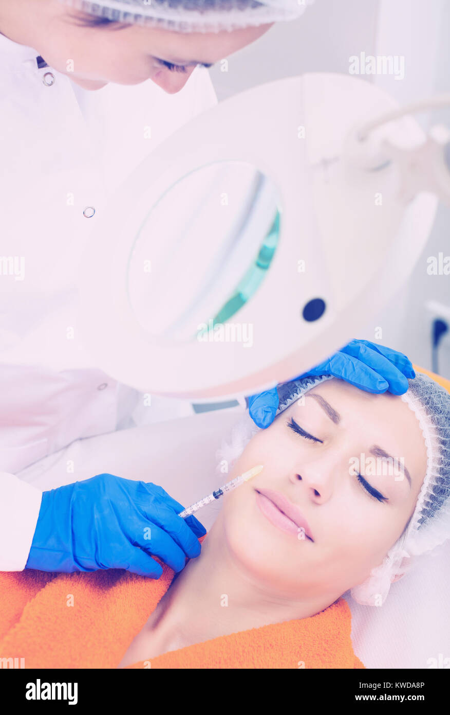 Doctor using injection in beauty procedures to woman client Stock Photo ...