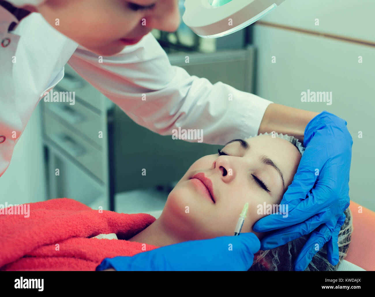 Adult female doctor using injection in beauty procedures to young woman ...