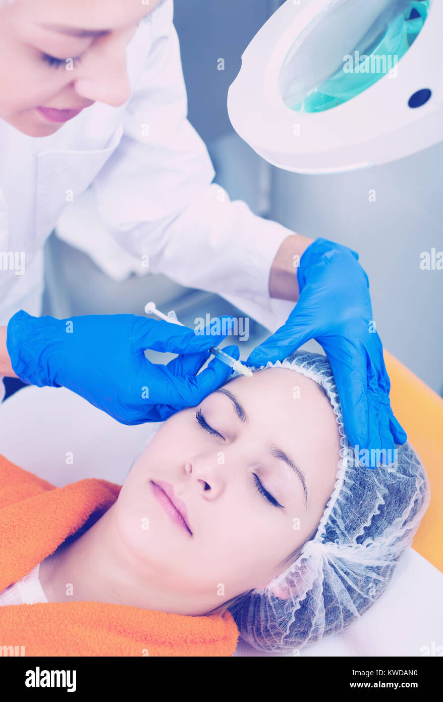 Female doctor using injection in beauty procedures to woman client ...