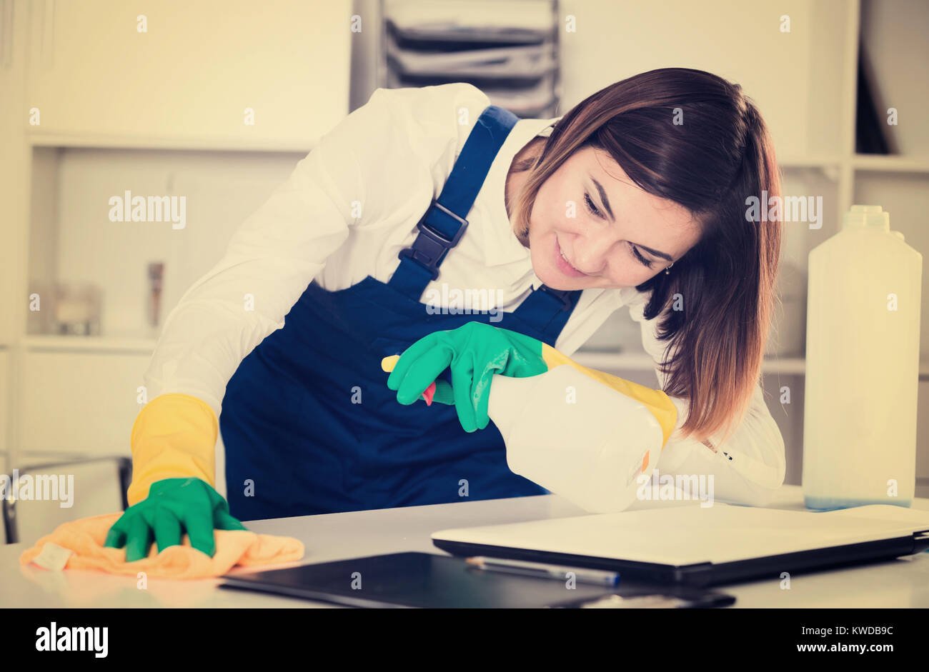 Smiling woman cleaner working effectively on task in office Stock Photo ...