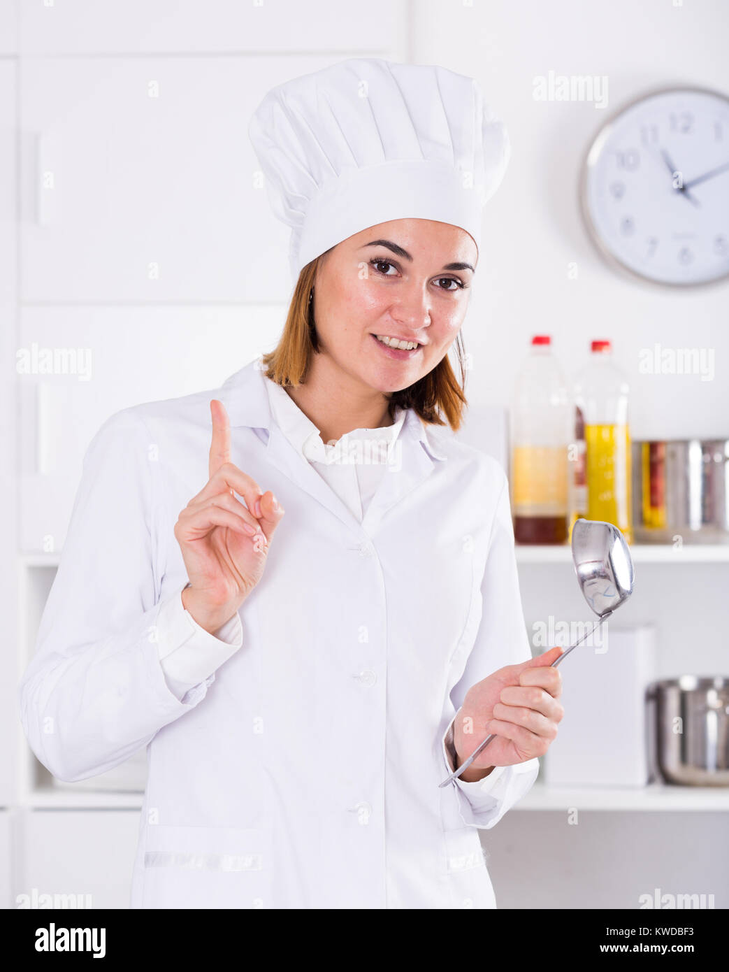 Smiling female cook practicing her skills in kitchen Stock Photo - Alamy