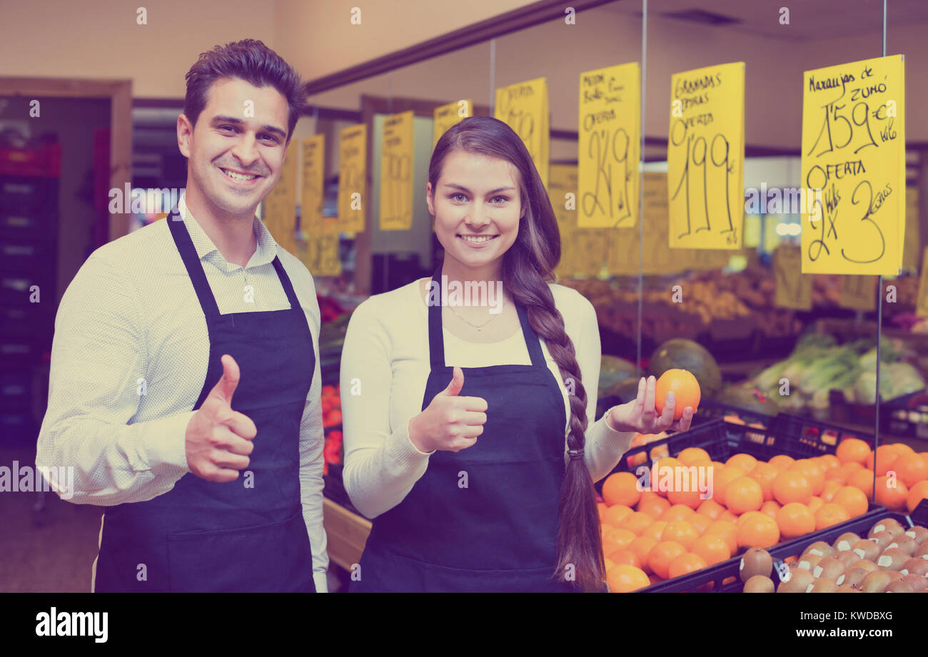 Positive sellers offering good price for fruits in grocery Stock Photo ...