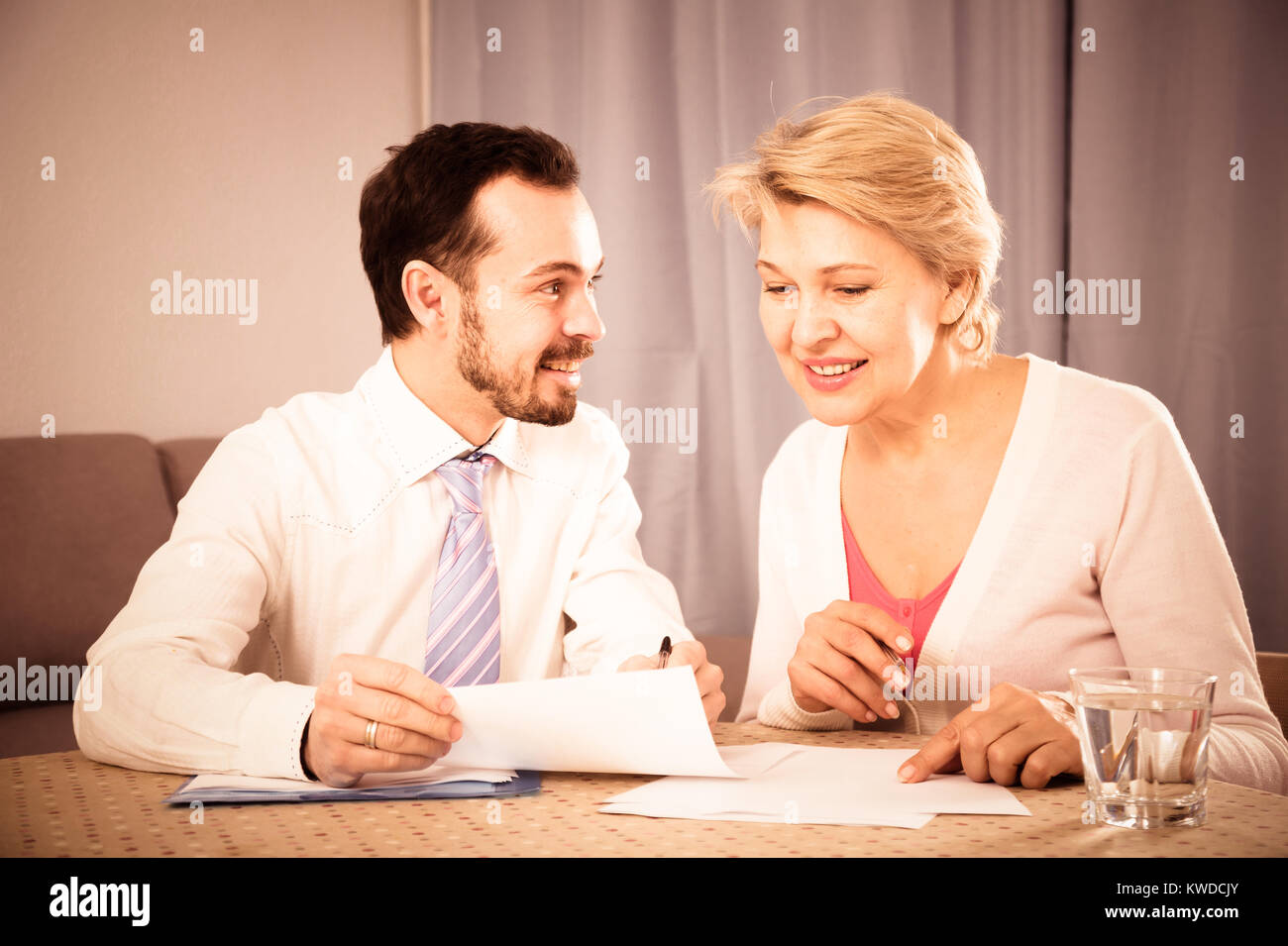 Old woman signing agreement papers with social worker at home Stock ...
