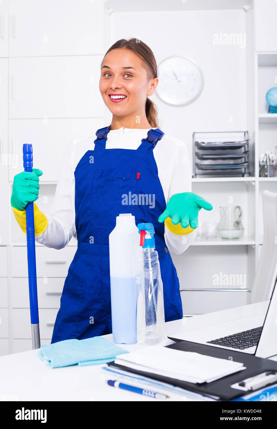 Smiling young girl wearing uniform cleaning at company office Stock ...