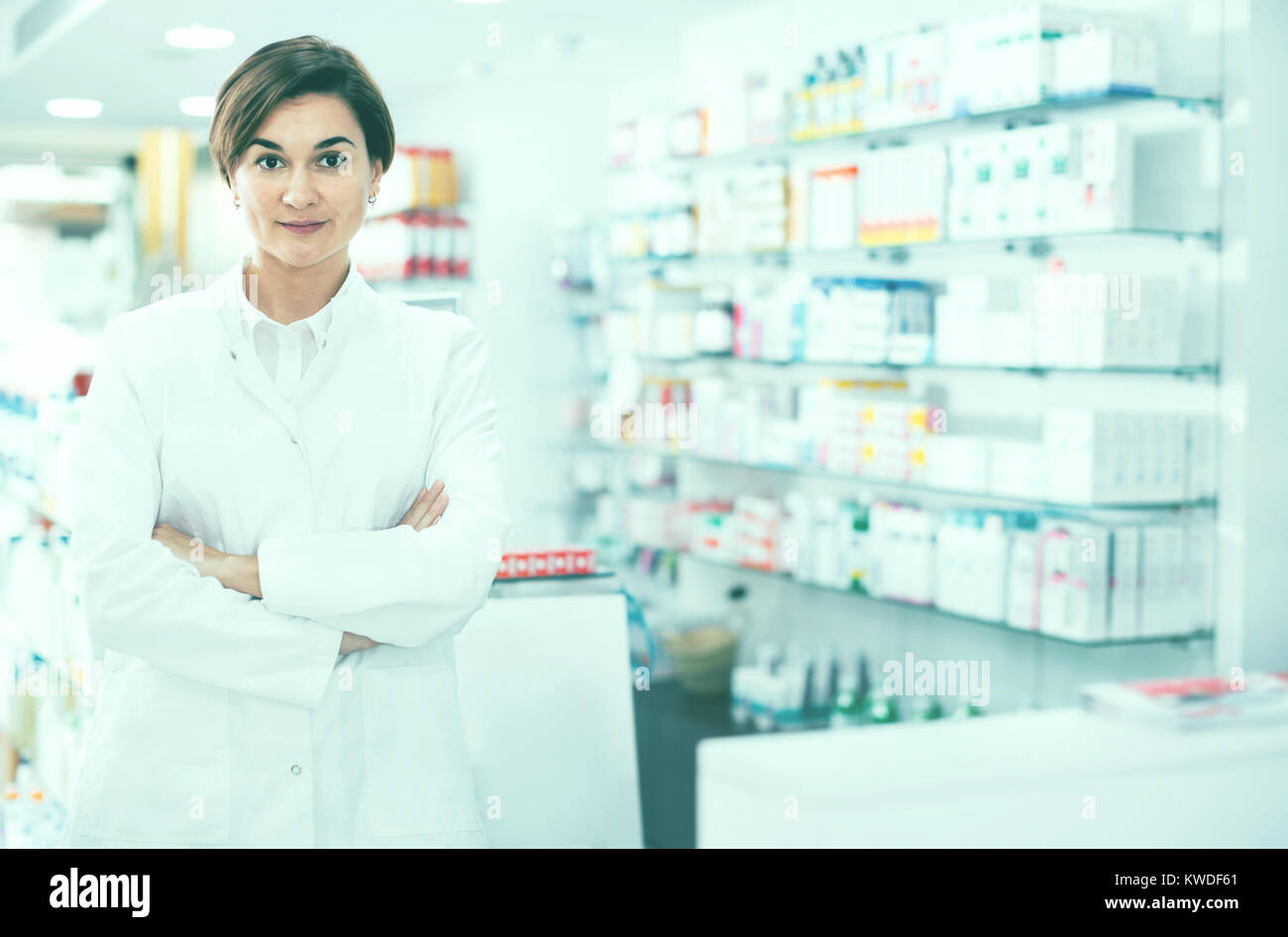 Young diligent friendly smiling female pharmacist arranging displayed ...