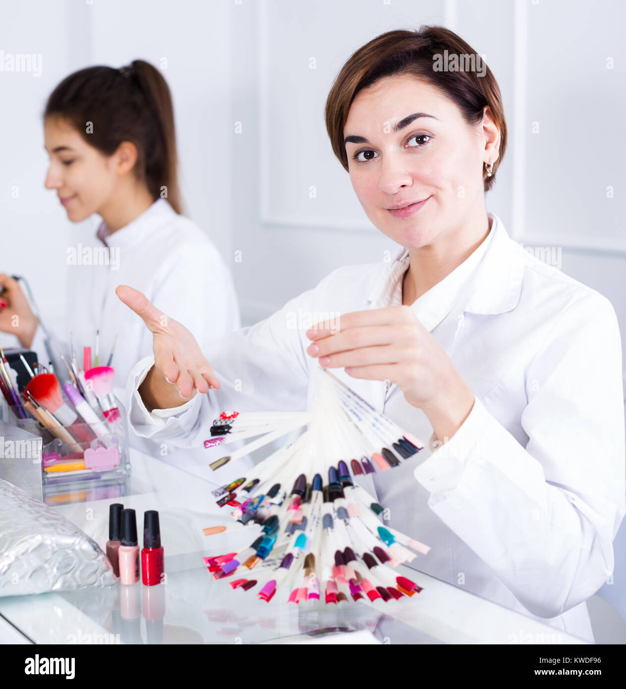 Happy woman manicurist demonstrating her workplace in nail salon Stock ...