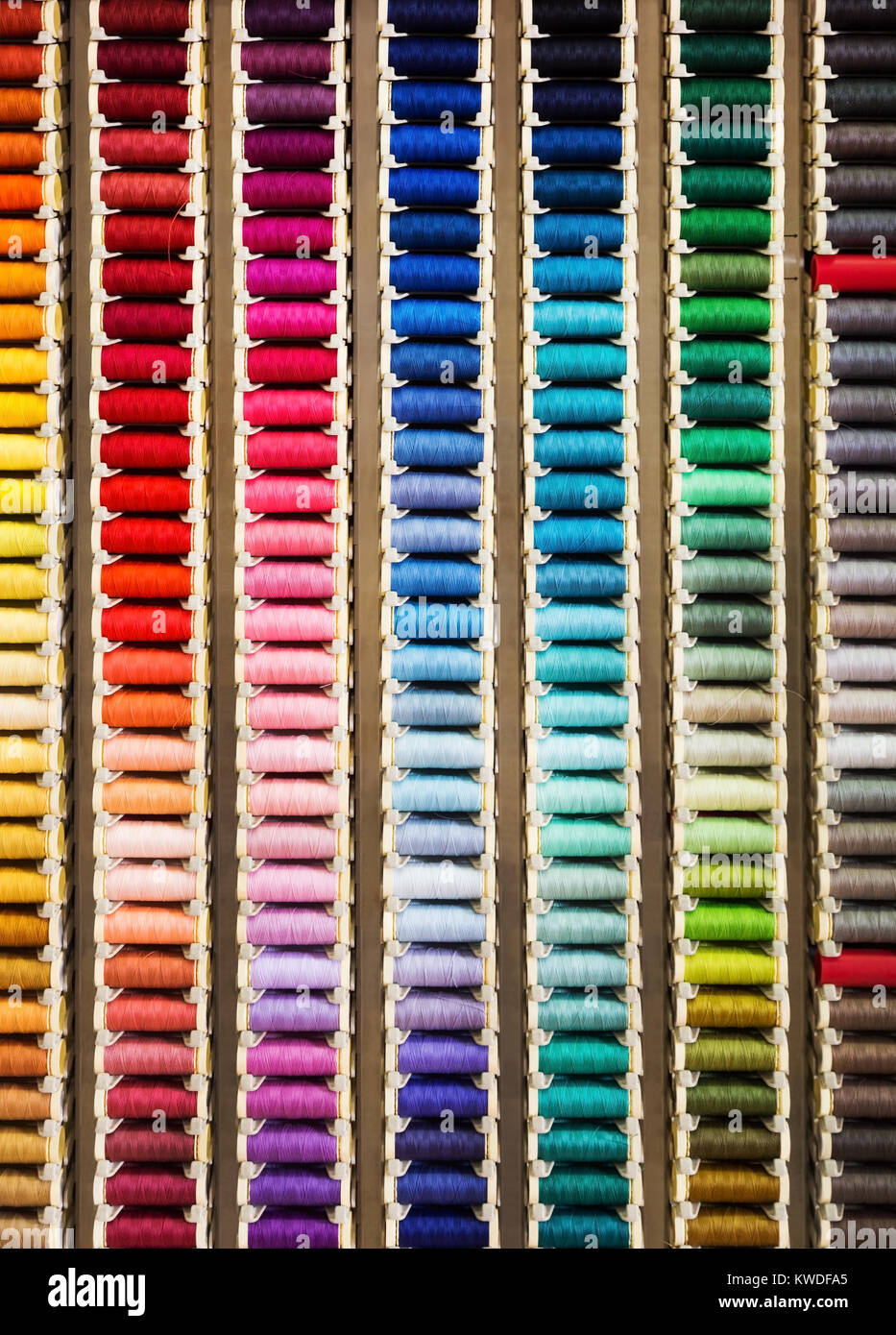 sewing threads in different bright colors in shop Stock Photo - Alamy
