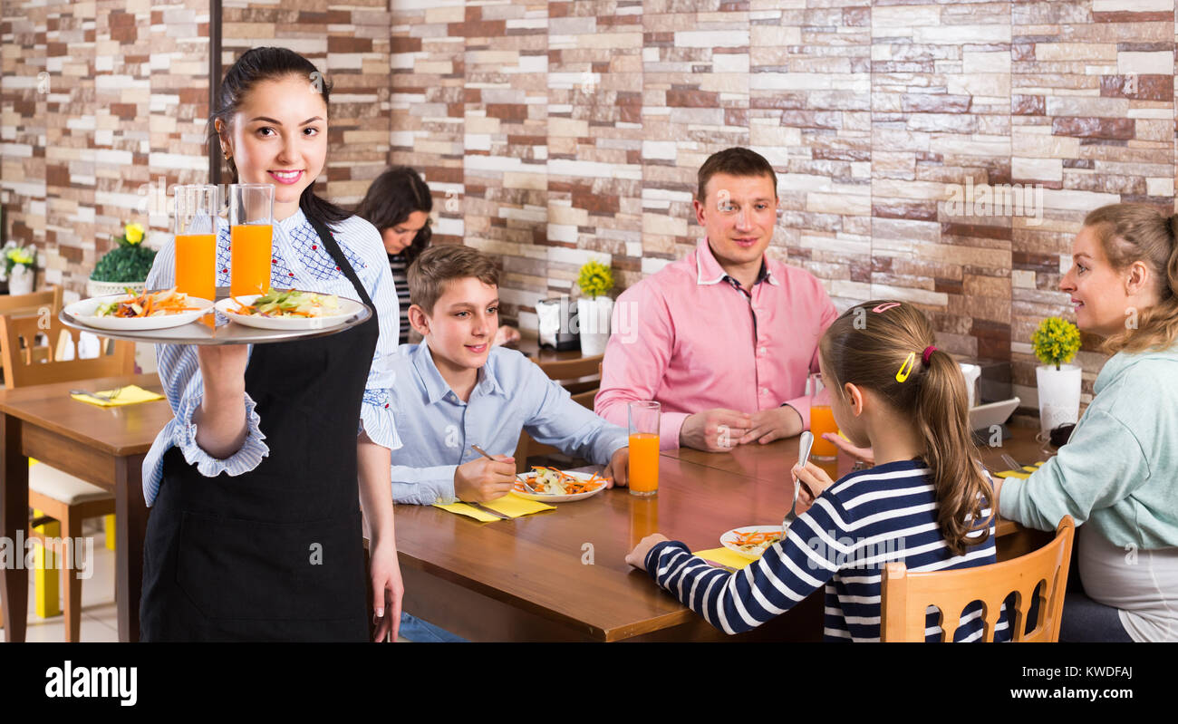 friendly young waitress warmly welcoming guests to comfortable family ...
