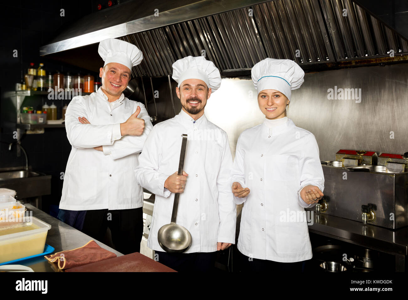 Happy professional chefs showing their workplace in restaurant’s ...