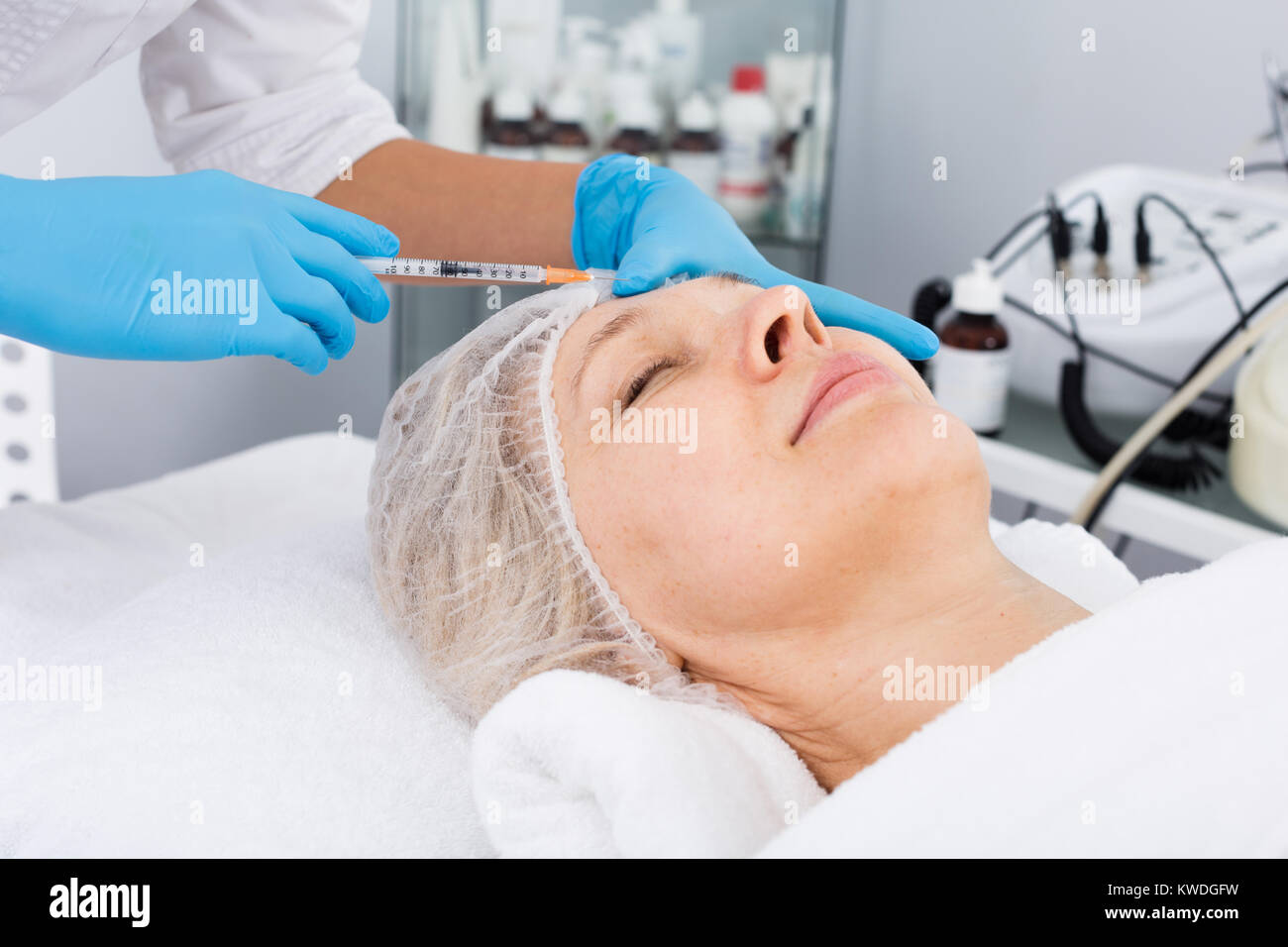 Woman doctor making beauty injection to aged female client Stock Photo ...