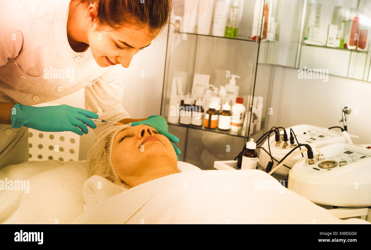 Female doctor doing beauty injection to mature woman client Stock Photo ...