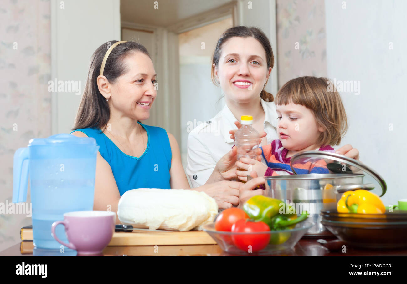 happy women with child cook vegetables in kitchen at home Stock Photo ...