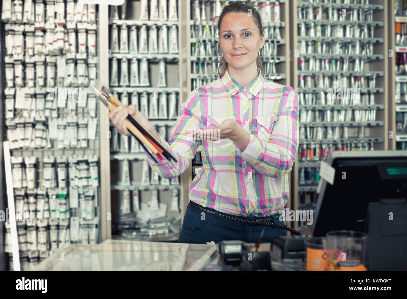 Young female seller posing at counter in art store Stock Photo - Alamy