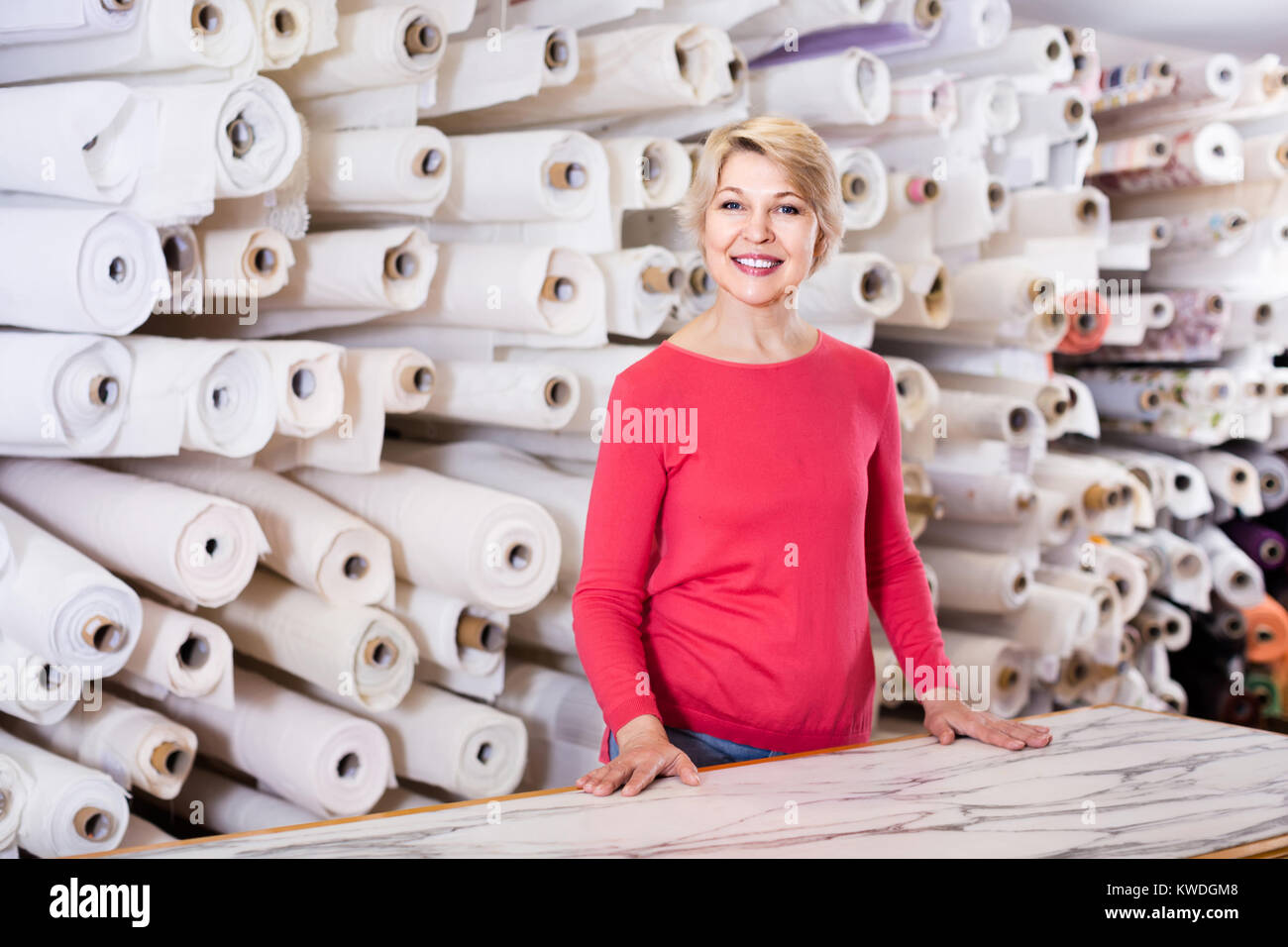 smiling russian female shop assistant demonstrating assortment at ...