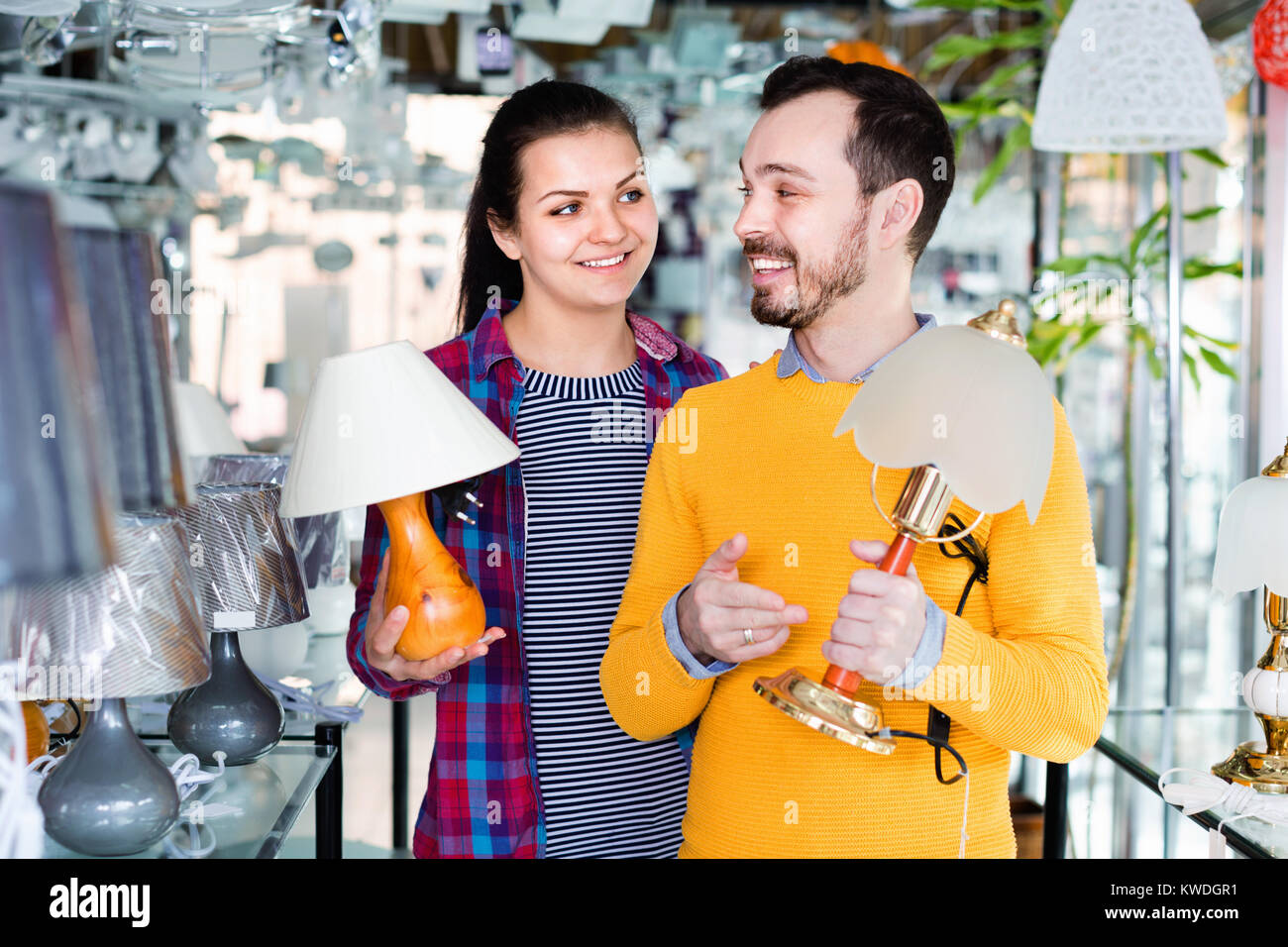 Smiling young cheerful positive man and girl in lighter shop choose ...