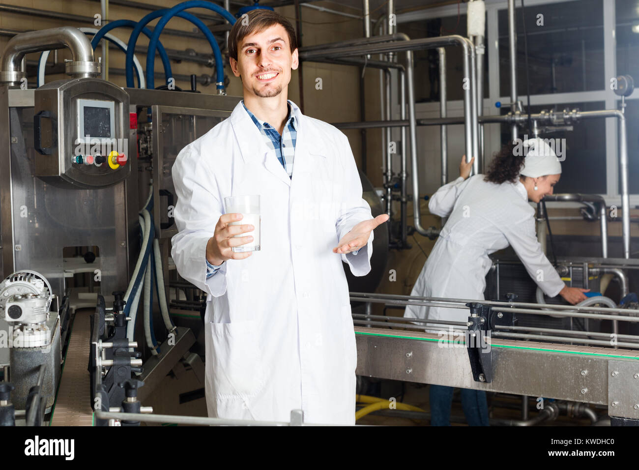 smiling man and woman dressed in lab coats working on the dairy ...