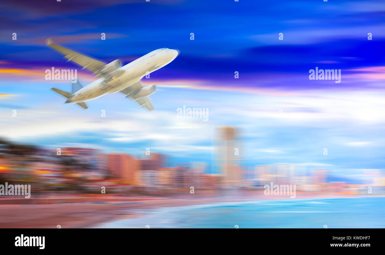 Airplane flying high in colored background with cityscape Stock Photo ...