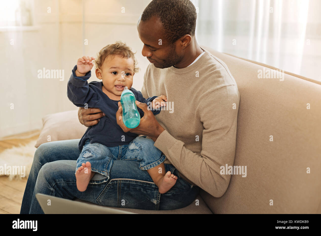 Happy daddy working and sitting with his son Stock Photo - Alamy