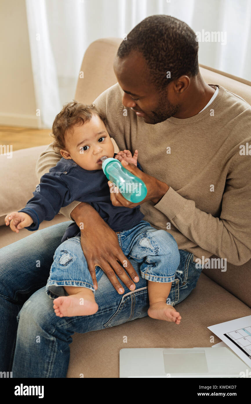 Smiling daddy feeding his little son Stock Photo - Alamy