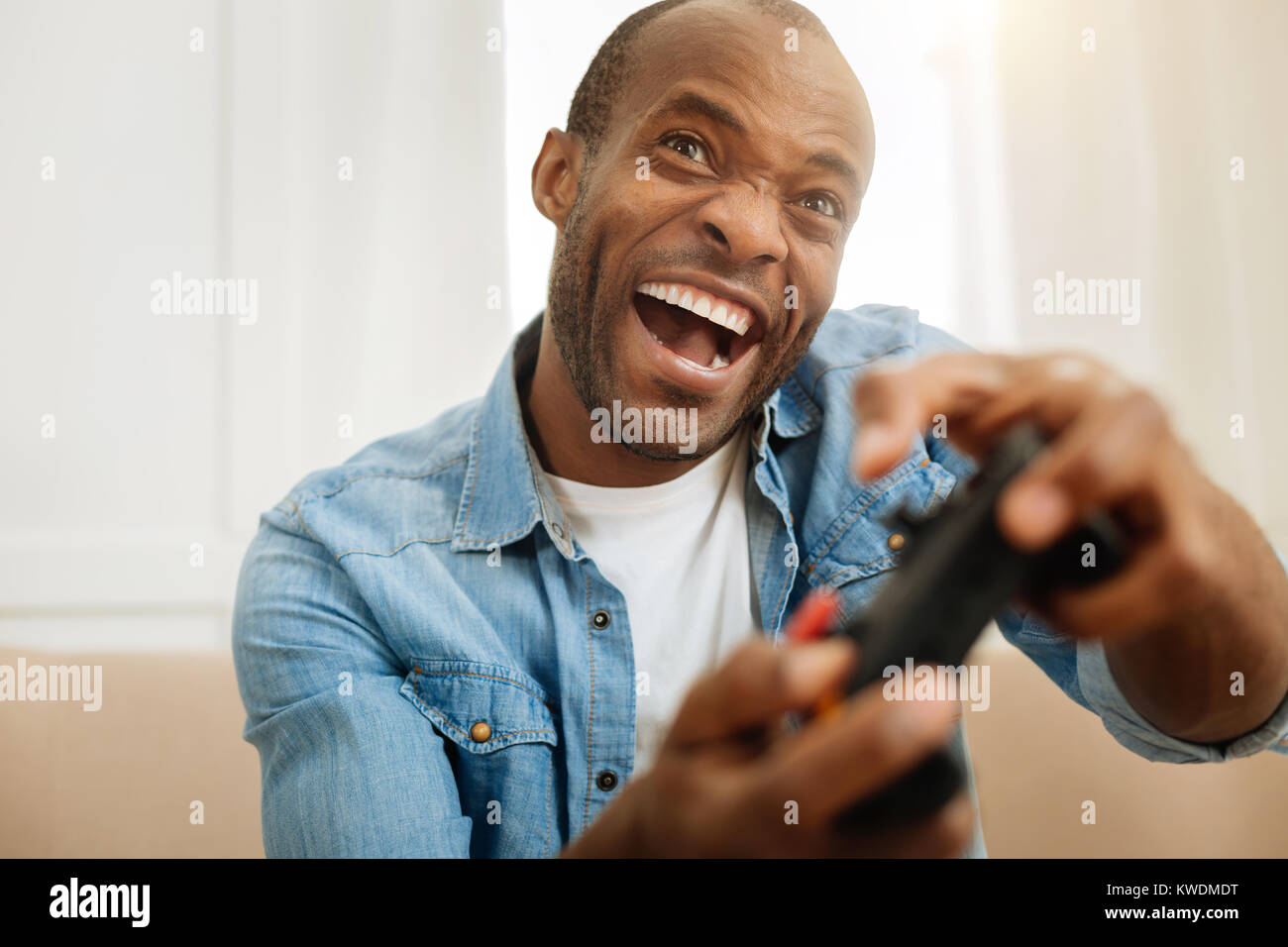 Gleeful man laughing and playing a game Stock Photo - Alamy