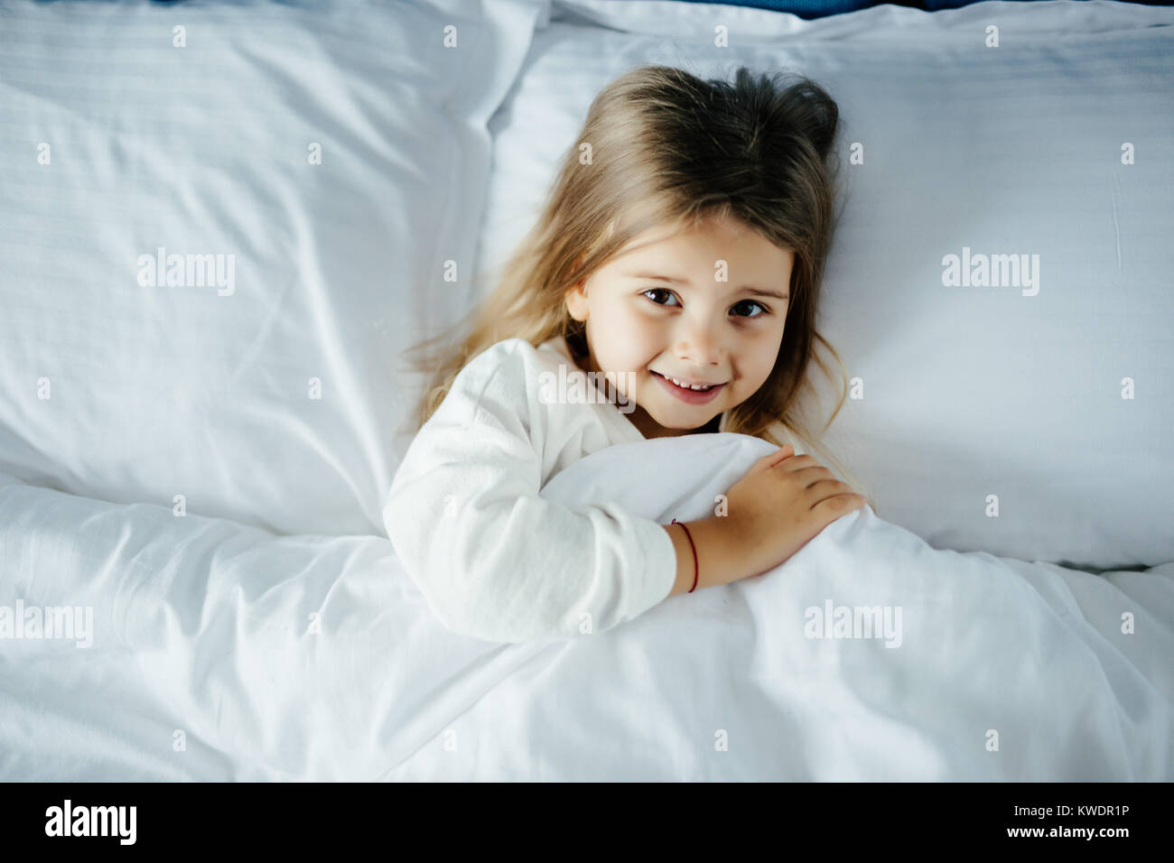 Top view of little girls while lying in bed at home Stock Photo - Alamy