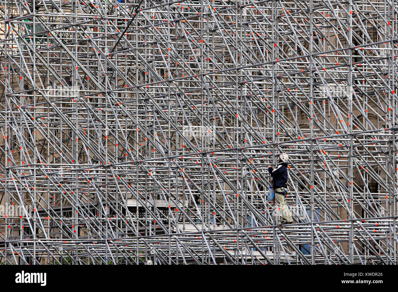 A worker on a scaffold working on a building construction Stock Photo ...