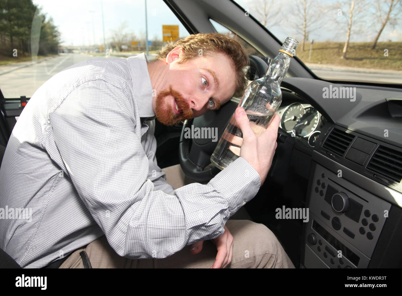 Drunk man sitting in drivers with a bottle alcohol Stock Photo - Alamy