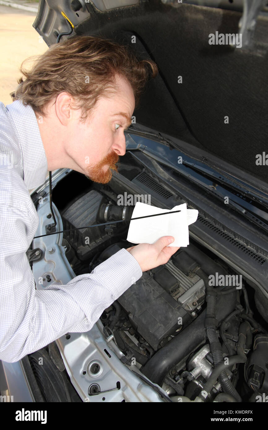 Funny man checking engine oil dipstick in car Stock Photo - Alamy