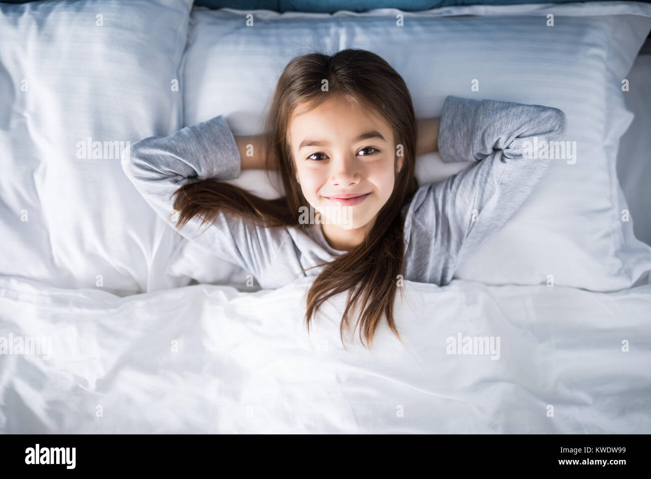 Top view of little girl lying in bed at home Stock Photo - Alamy