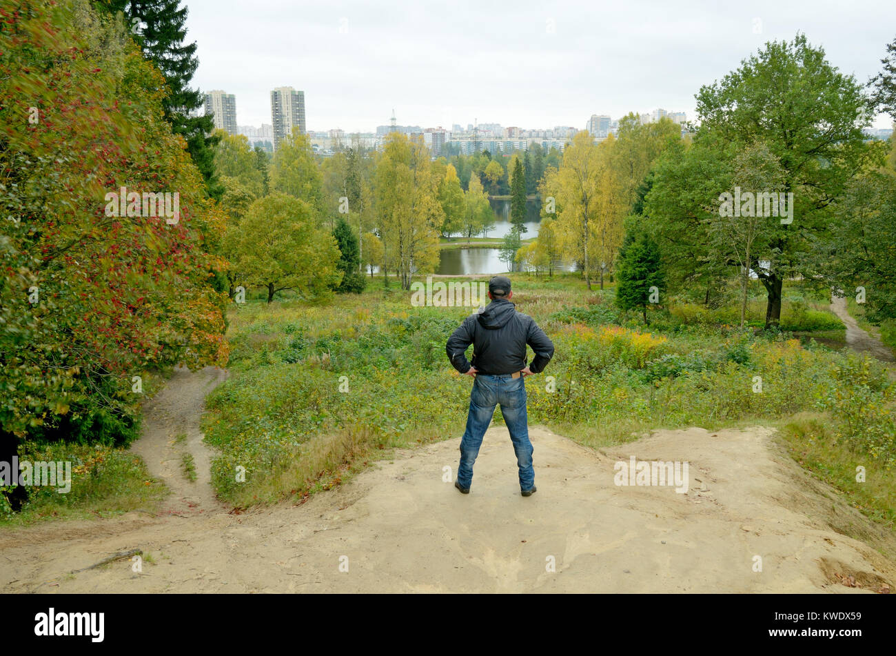A man stands on the hill.He looks at the natural landscape from the ...