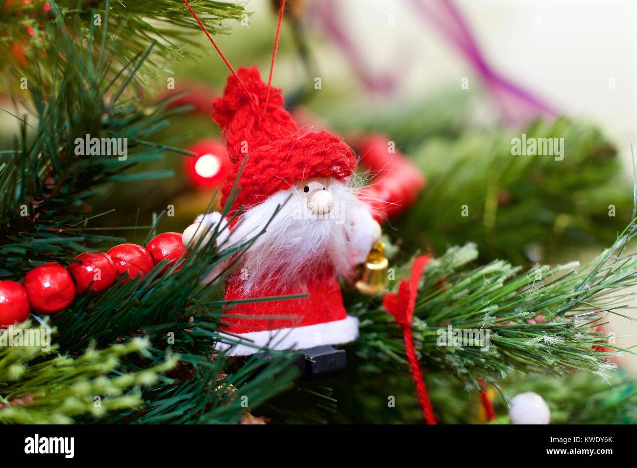 Santa Claus Christmas decoration hanging on a tree in a festive display ...