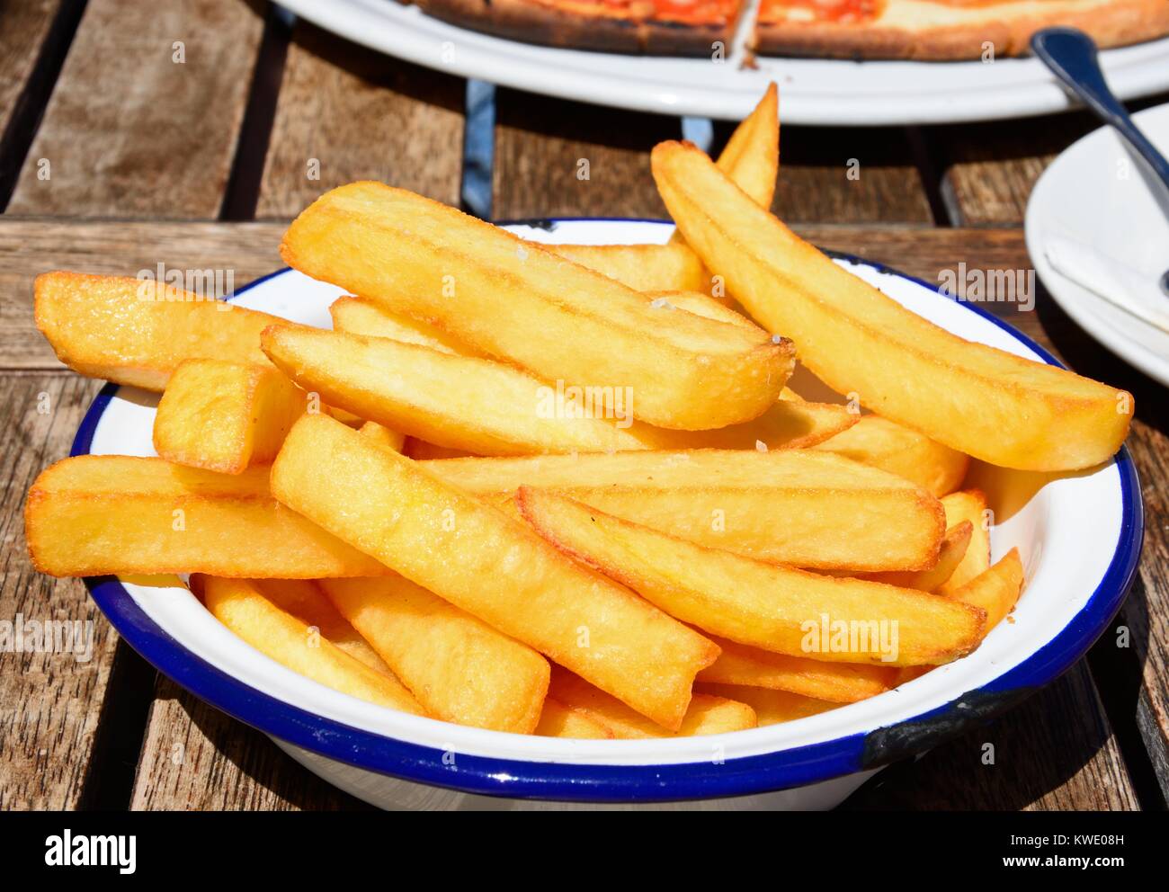 Crispy chunky chips in a metal dish on a wooden table within the ...