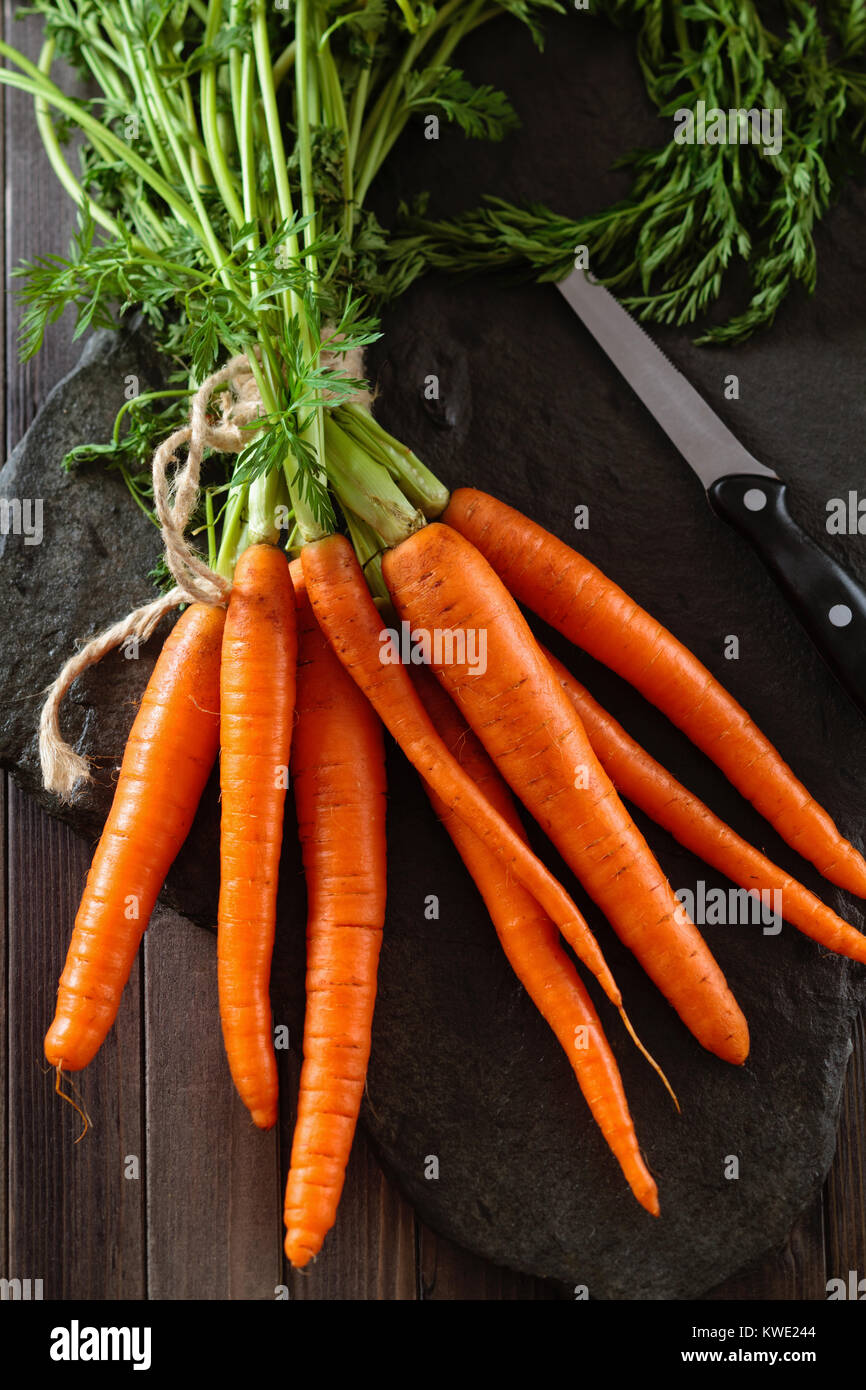 Heap of ripe carrots with leaves on dark slate Stock Photo - Alamy