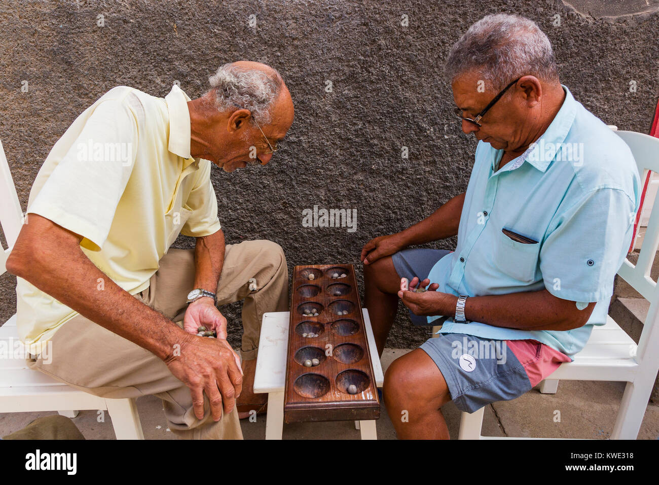 Two local men playing the traditional African board game called ouril ...