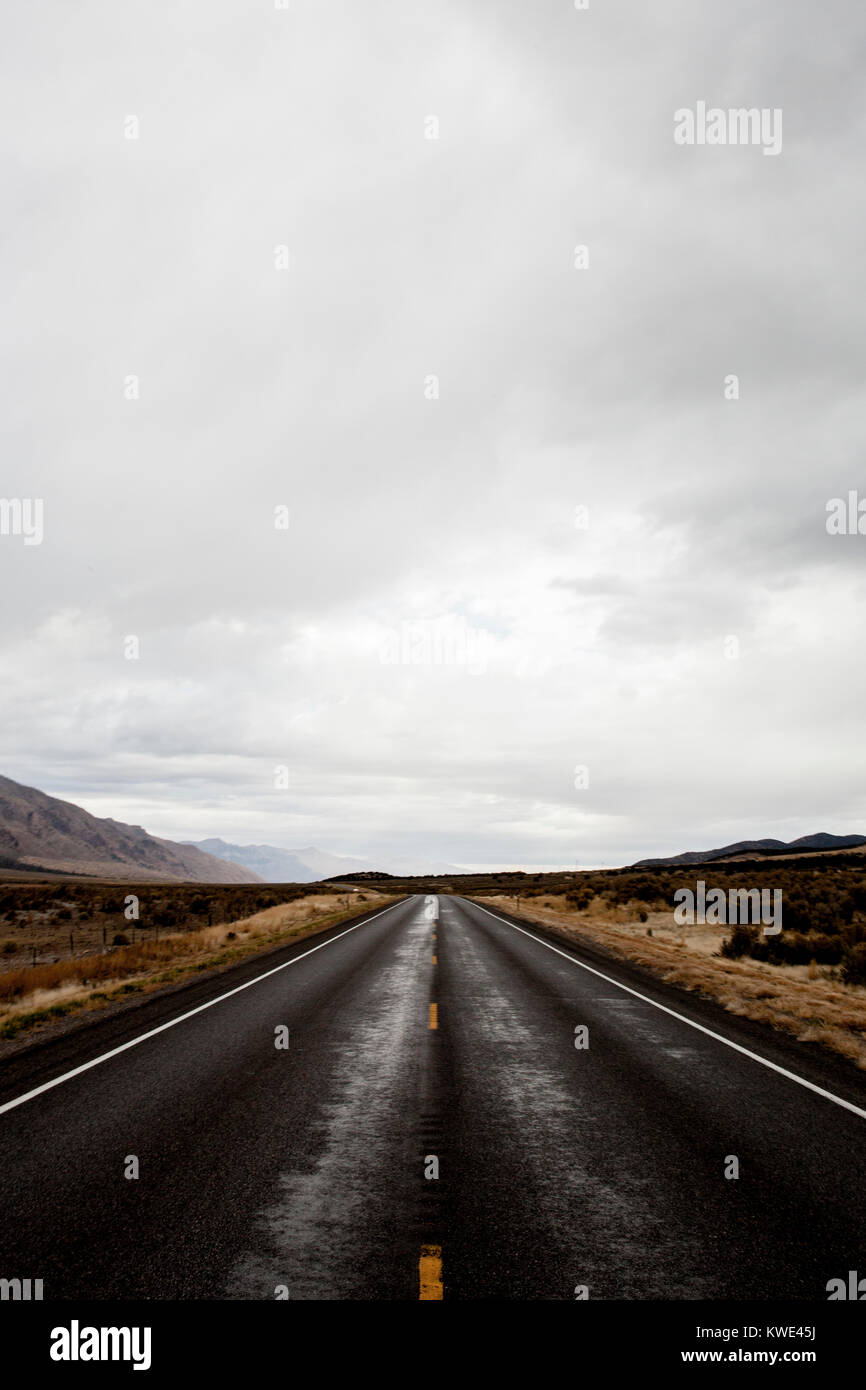 Single lane road amidst field against cloudy sky Stock Photo - Alamy