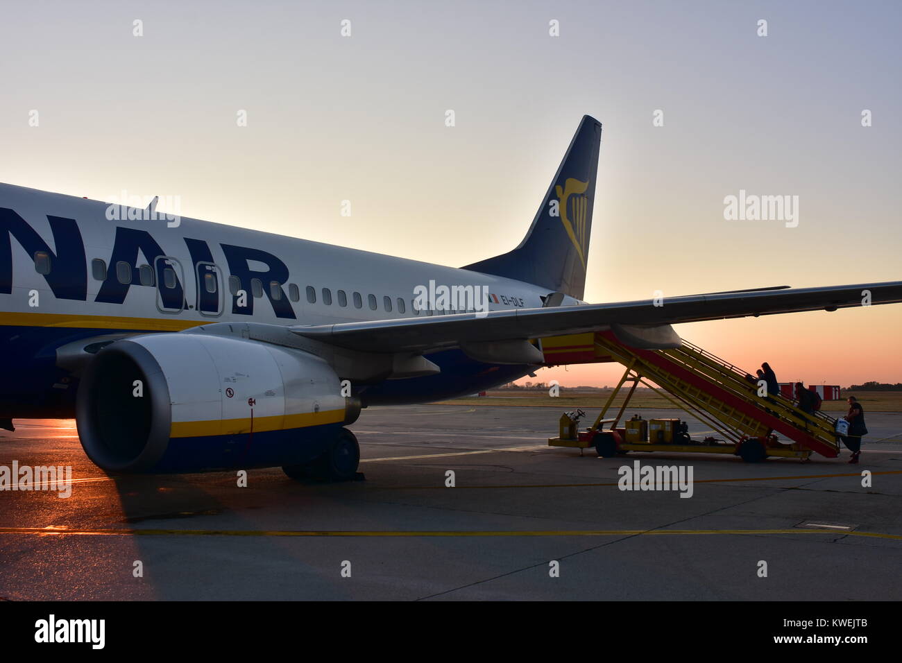 Passengers boarding Ryanair jet plane parked on concrete runway at ...