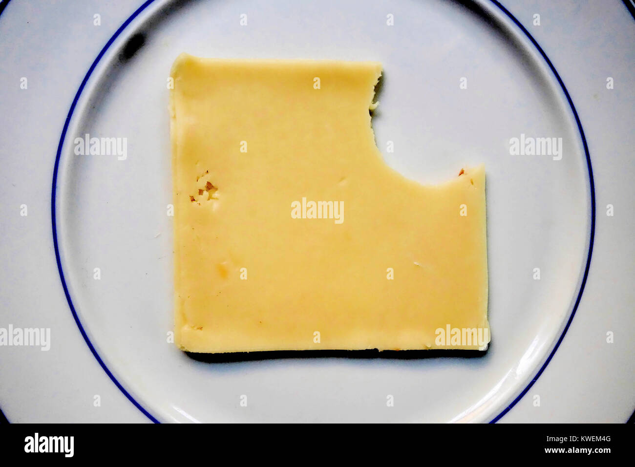 Bitten Cheese Slices on a plate Stock Photo - Alamy
