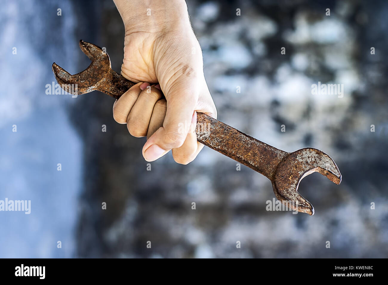 human hand holding old rusted spanner Stock Photo - Alamy