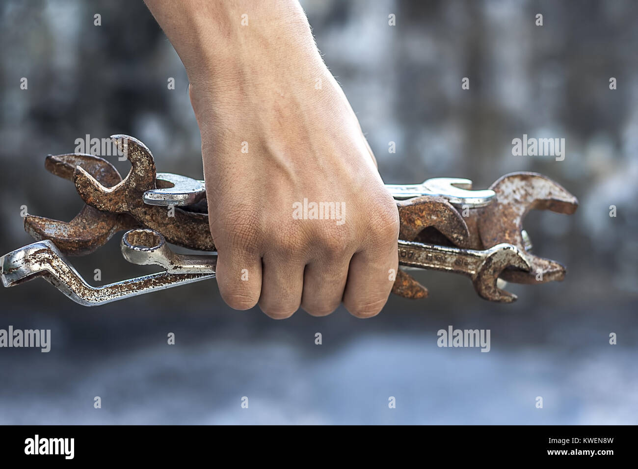 human hand holding old rusted spanner Stock Photo - Alamy