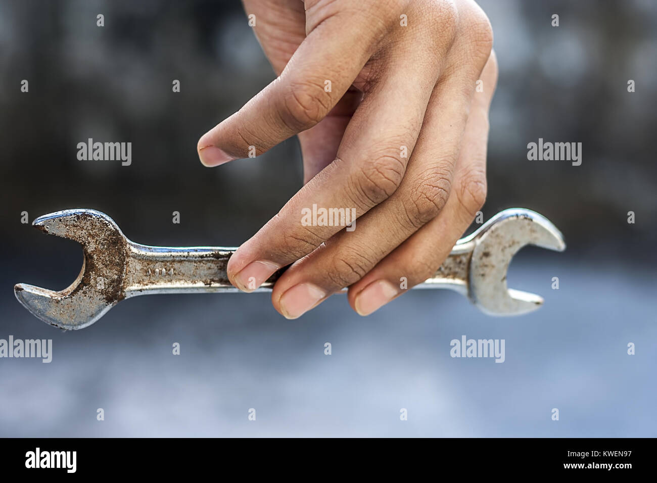 human hand holding old rusted spanner Stock Photo - Alamy