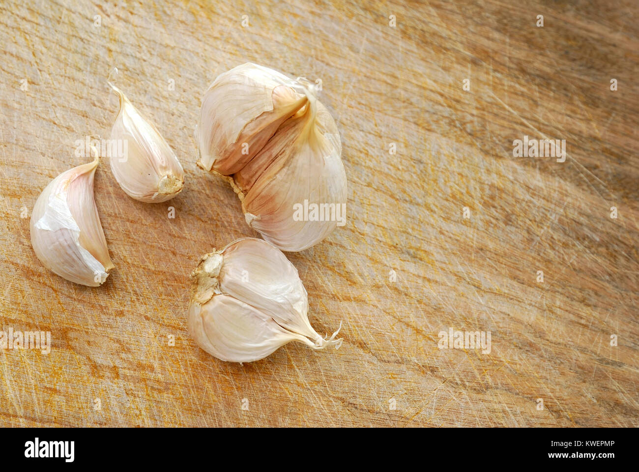 Fresh garlic cloves on chopping board. Commonly used as seasoning and ...