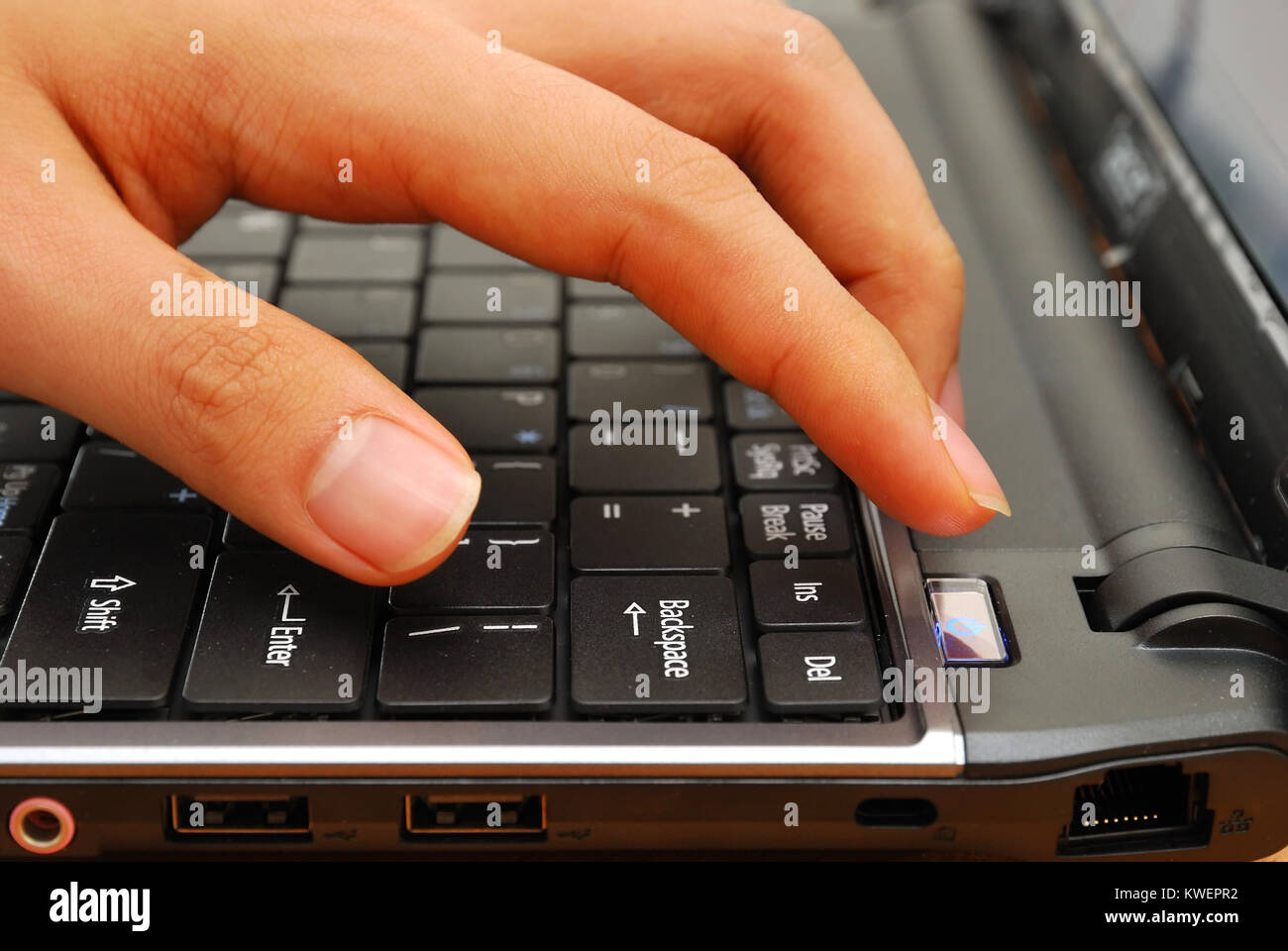 Finger pressing power button on laptop kepboard. For concepts such as ...