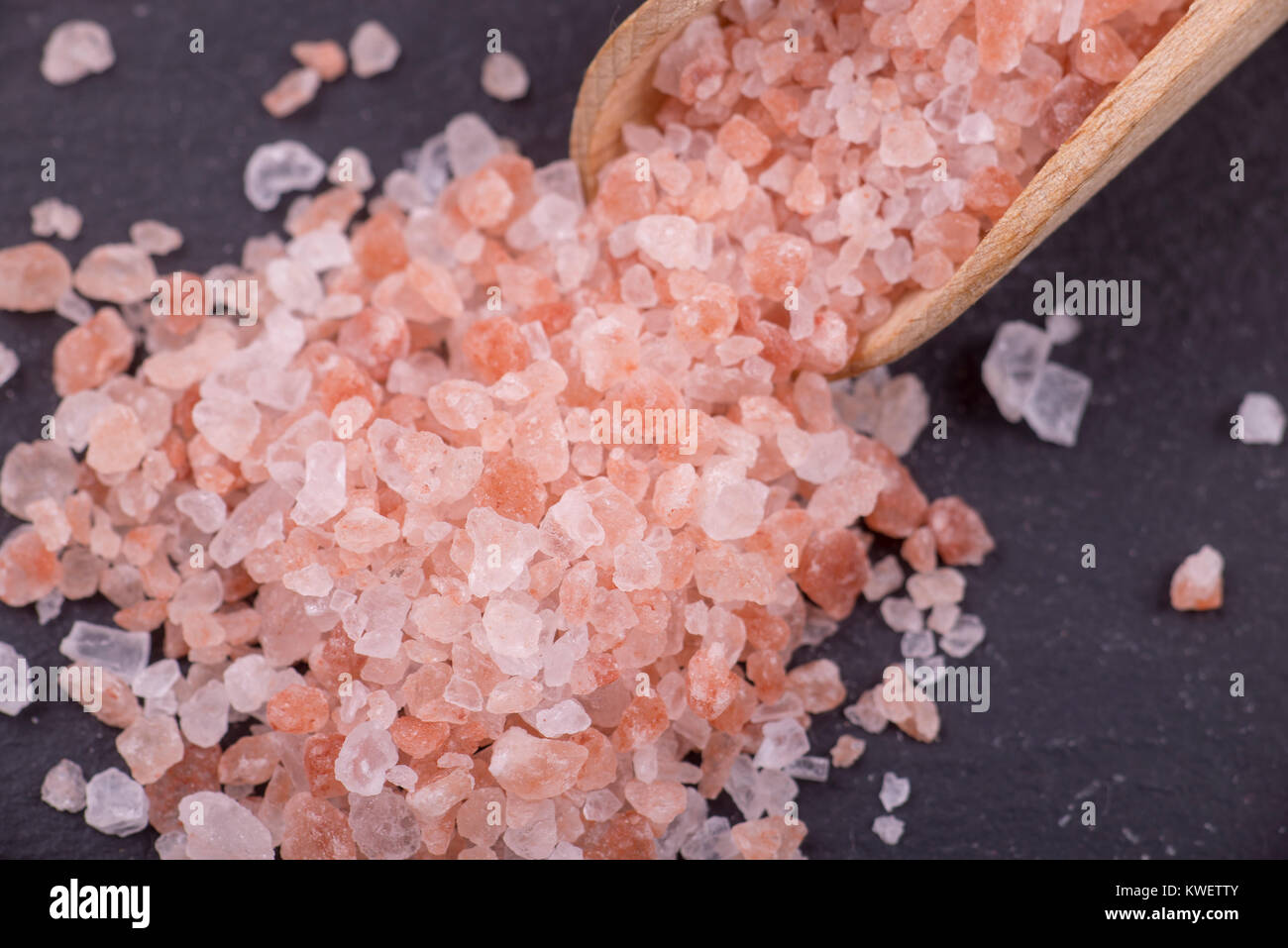 Himalayan red salt with wooden spoon on black slate plate Stock Photo ...