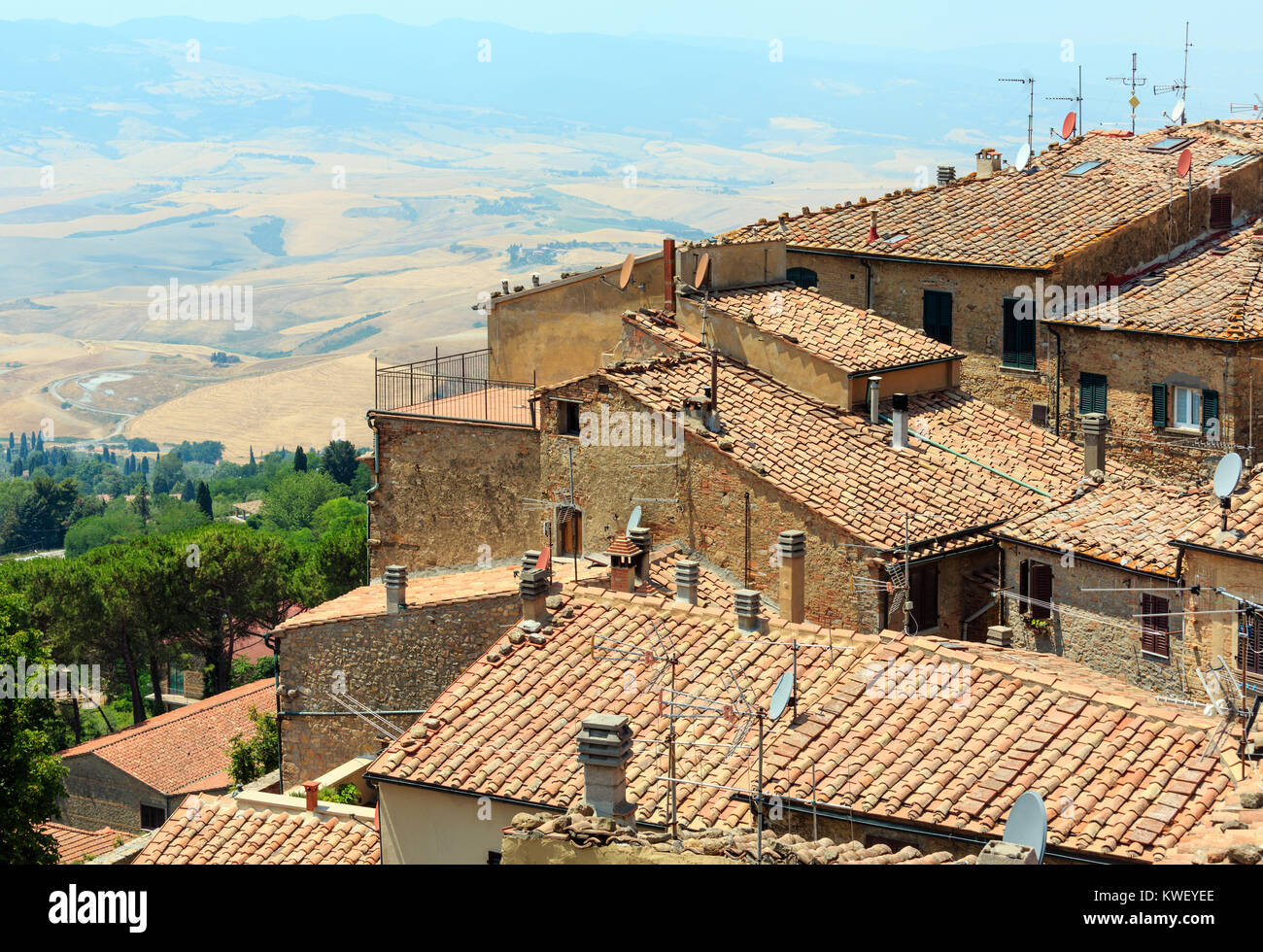 Summer ancient walled mountaintop town Volterra and farmland below ...
