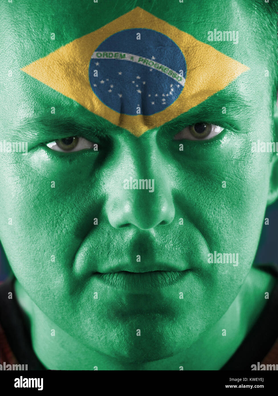 Closeup of young Brazilian supporter face painted with national flag ...