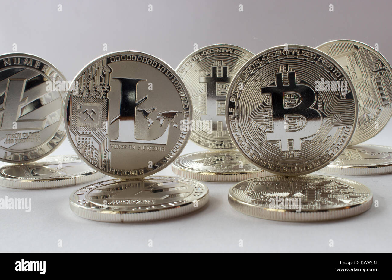 On a white background are silver coins of a digital crypto currencies ...