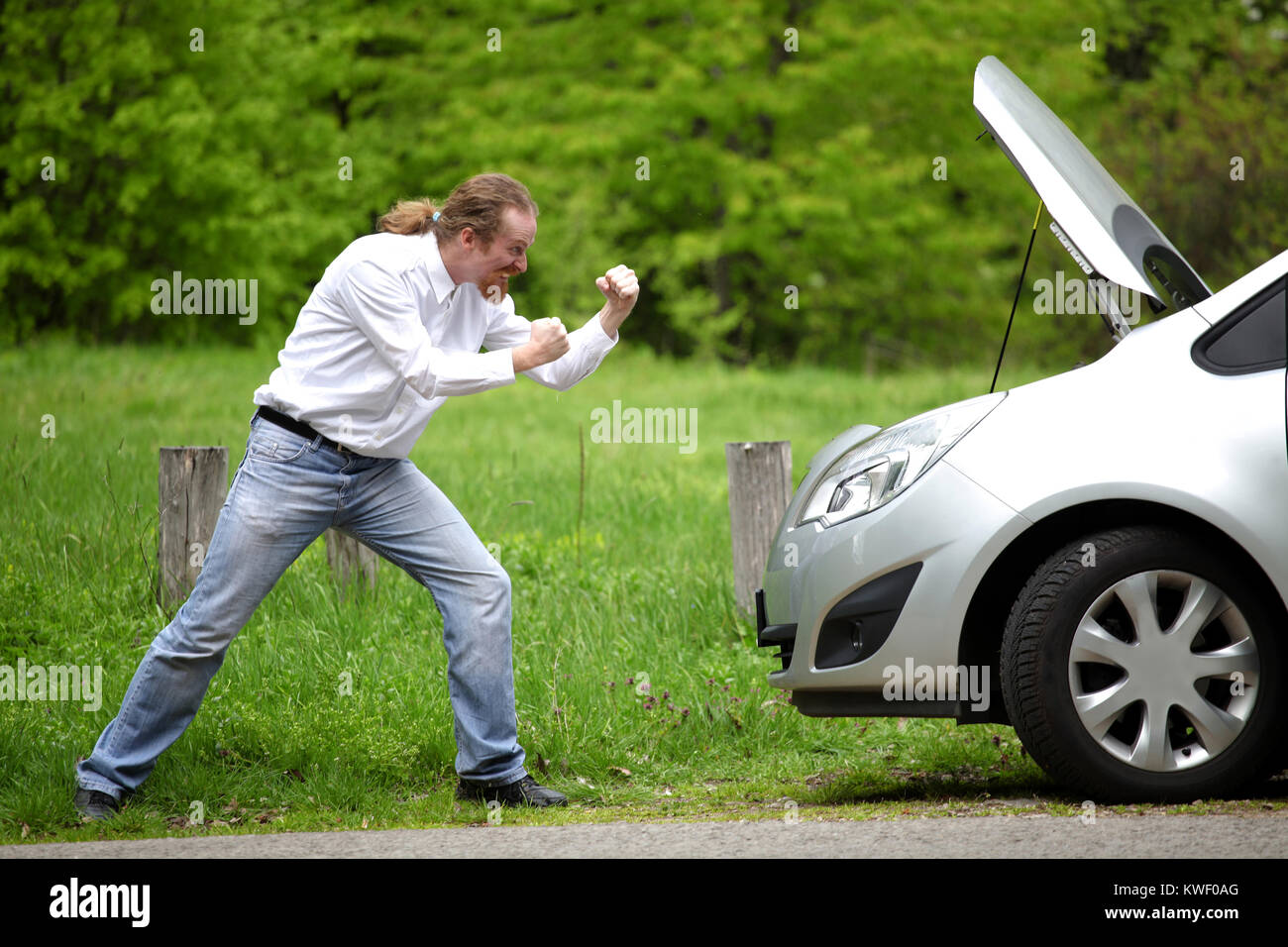 Driver furious a broken car by the road Stock Photo - Alamy