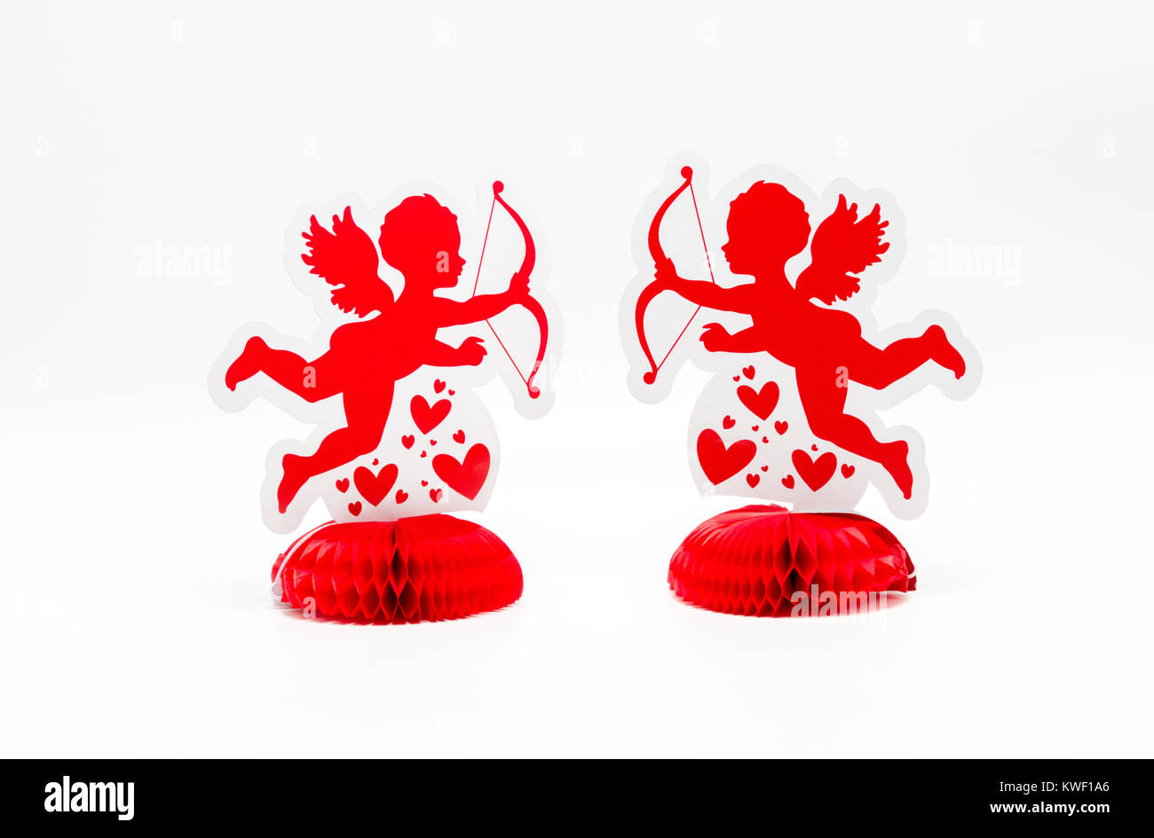 2 bright red cupid decorations with hearts isolated on plain background ...
